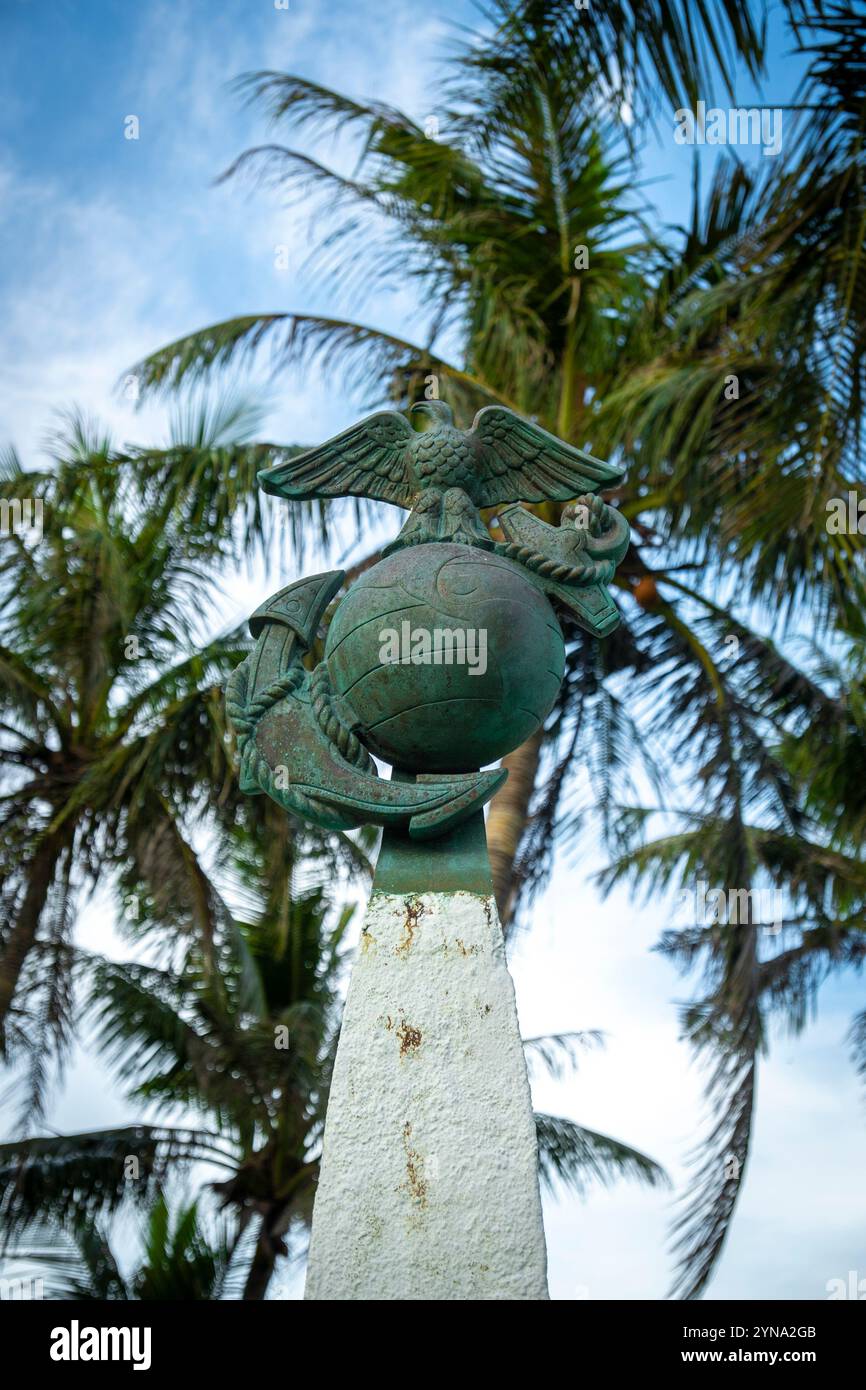 Monument honoring military history in Guam surrounded by palm trees and ...