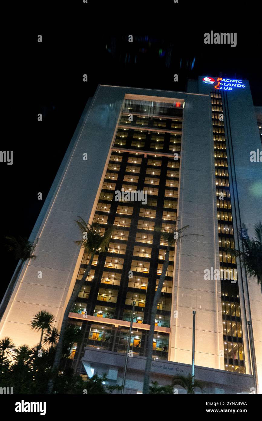 Urban night view of a tall building with illuminated windows in a city ...