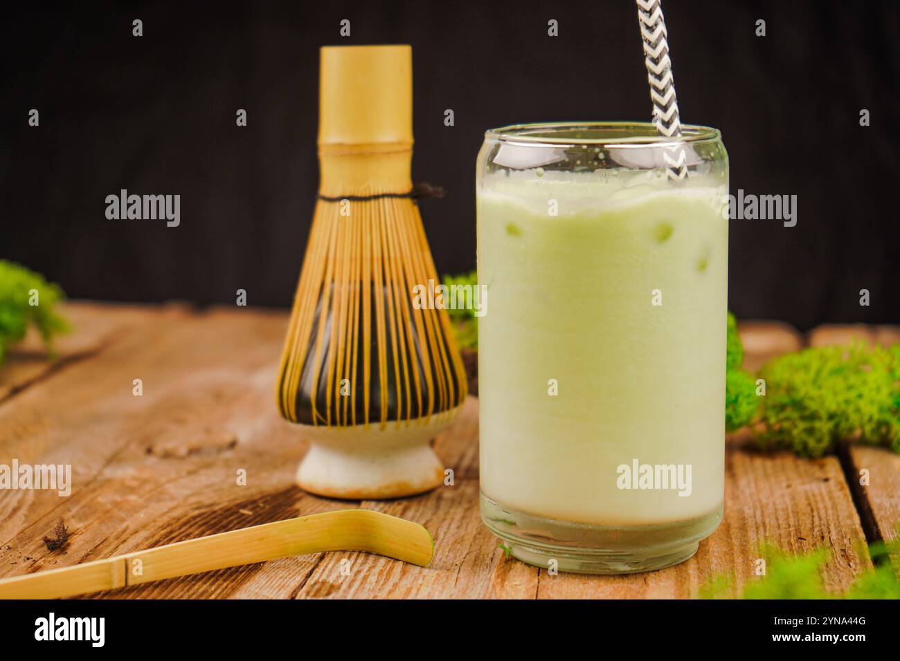 A close-up shot of a bamboo matcha whisk resting on a matcha table ...