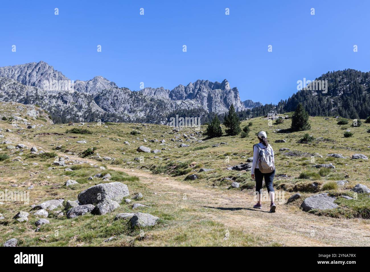 Female middle aged Spanish tourist walking by Spanish Pyrenees mountain ...