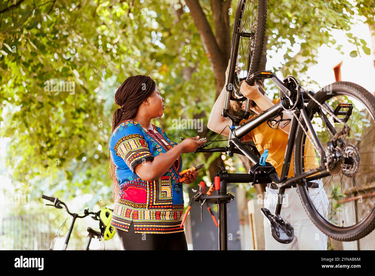 Young active black woman selecting suitable work tool for healthy man ...