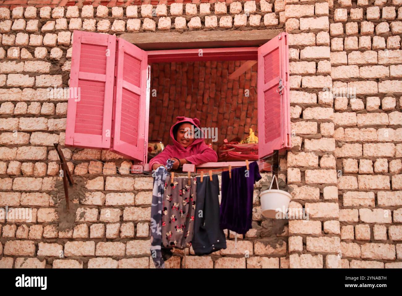 Aswan, Egypt. 24th Nov, 2024. A girl collects clothes at a Nubian village in Aswan, Egypt, Nov ...