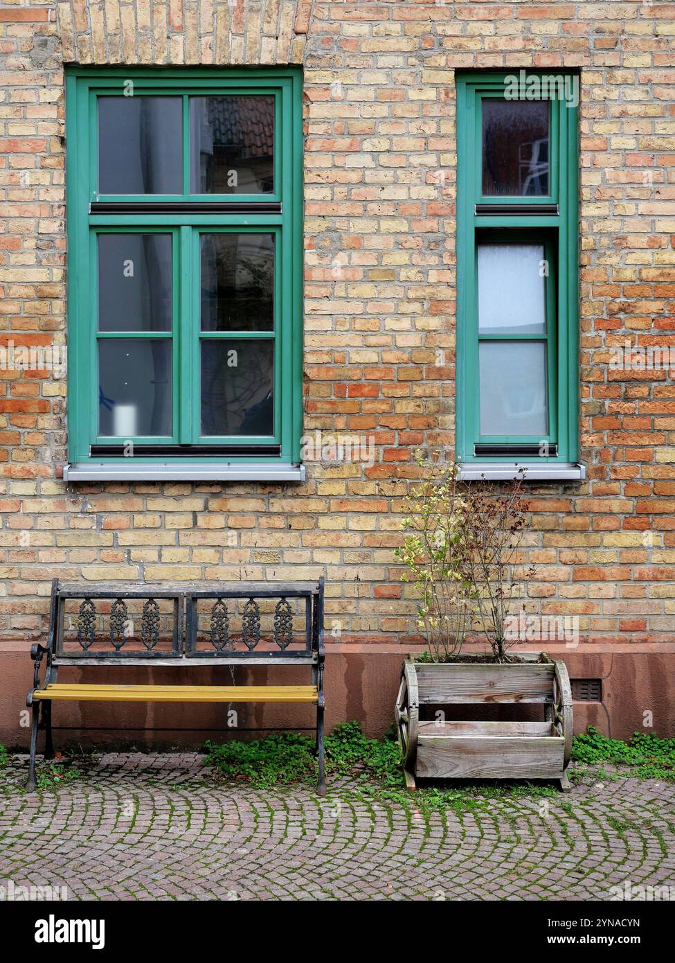 Rustic bench in front of a historic yellow facade with green lattice ...