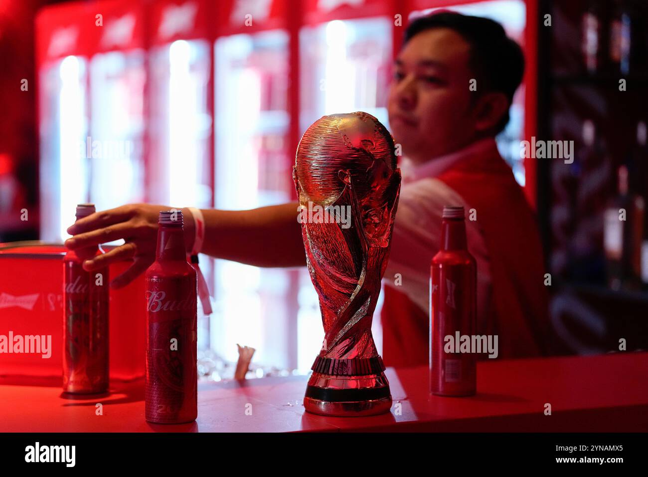 FILE - A bartender clears bottles of Budweiser beer from the bar near a ...