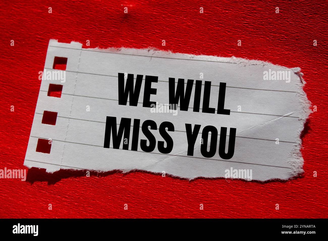 We will miss you message written on ripped torn paper piece with red background. Conceptual we ...