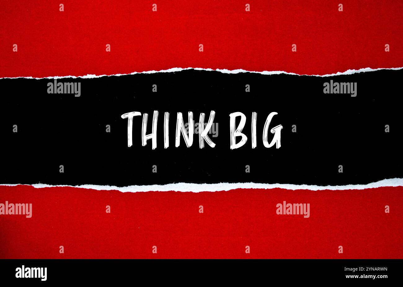 Think big message written on ripped torn red paper with black background. Conceptual think big ...
