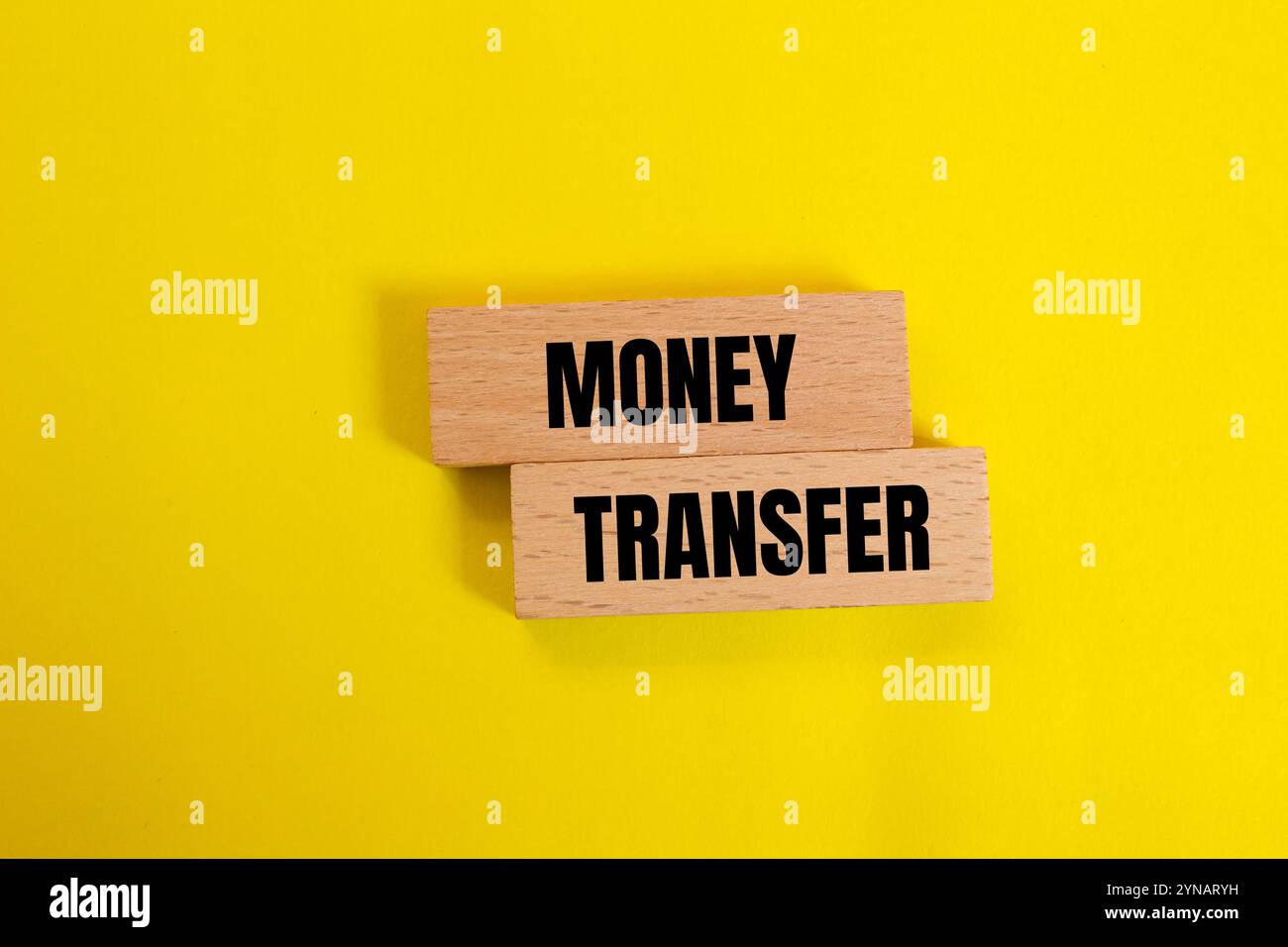 Money transfer message written on wooden blocks with yellow background ...