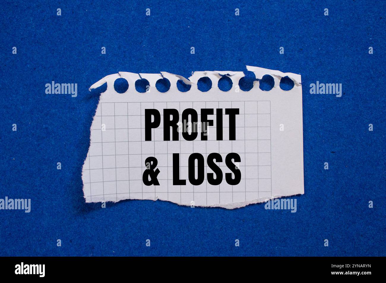 Profit and loss message written on ripped torn paper piece with blue ...