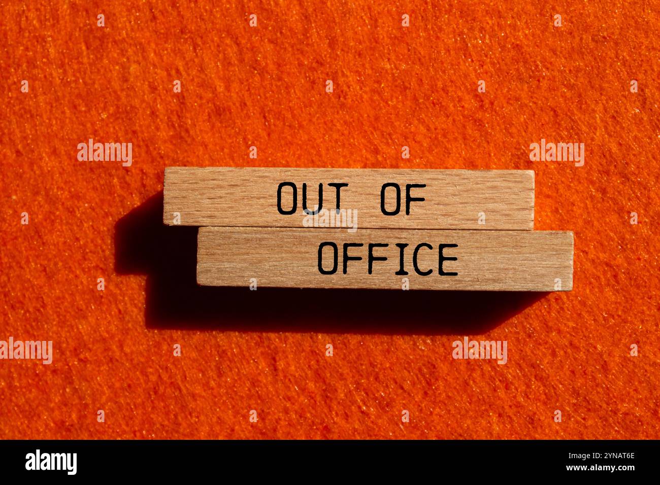 Out of office message written on wooden blocks with orange background ...