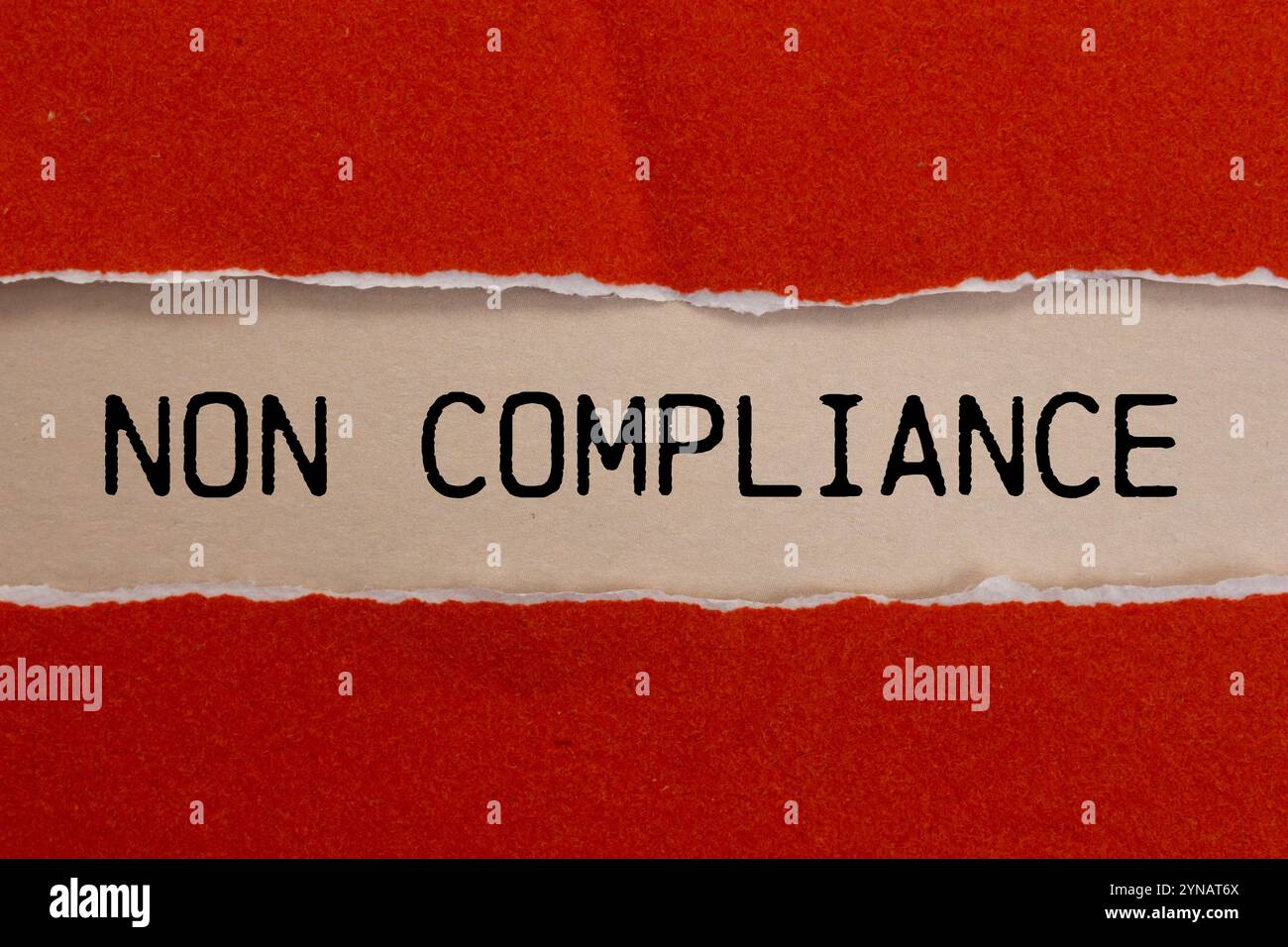 Non compliance message written on ripped torn red paper with beige ...