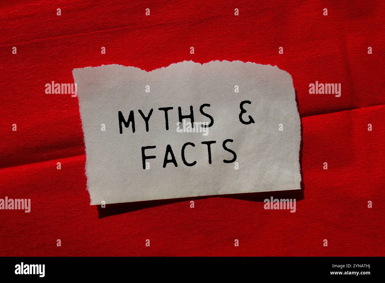 Myths and facts message written on ripped torn paper piece on red ...