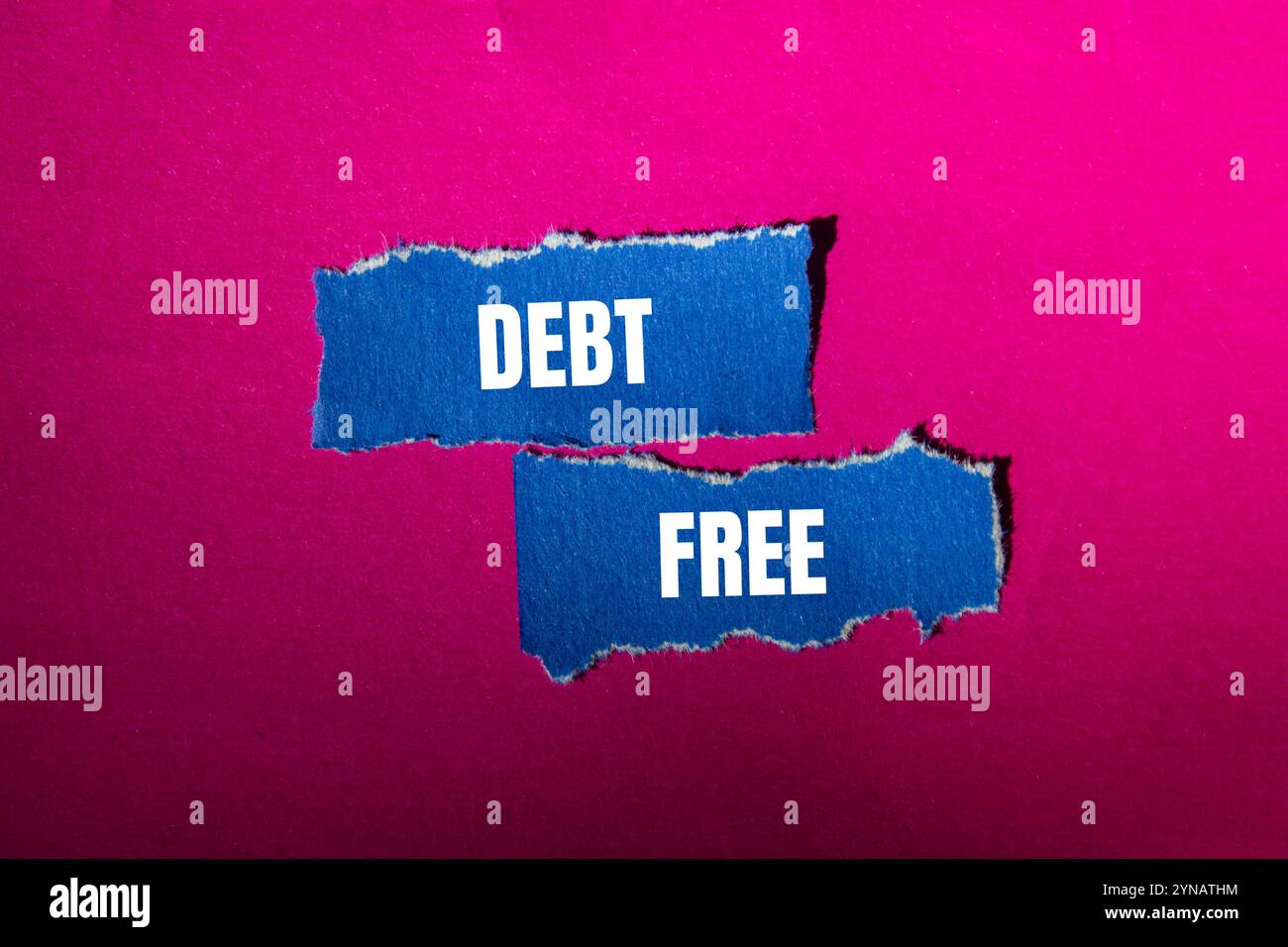 Debt free message written on ripped torn blue paper pieces with pink ...