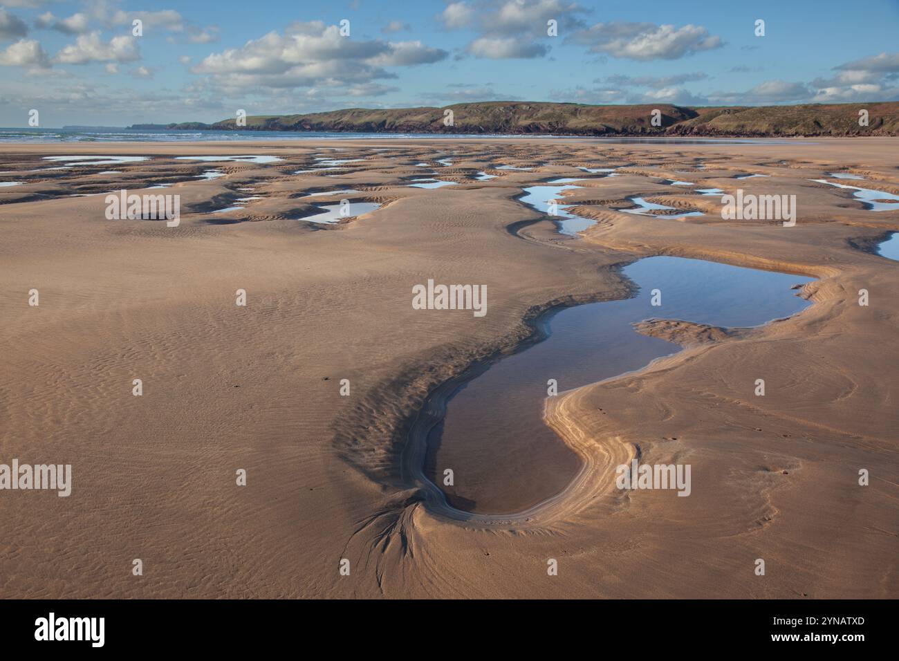 Beach pools left in sand after tide has gone out Stock Photo - Alamy