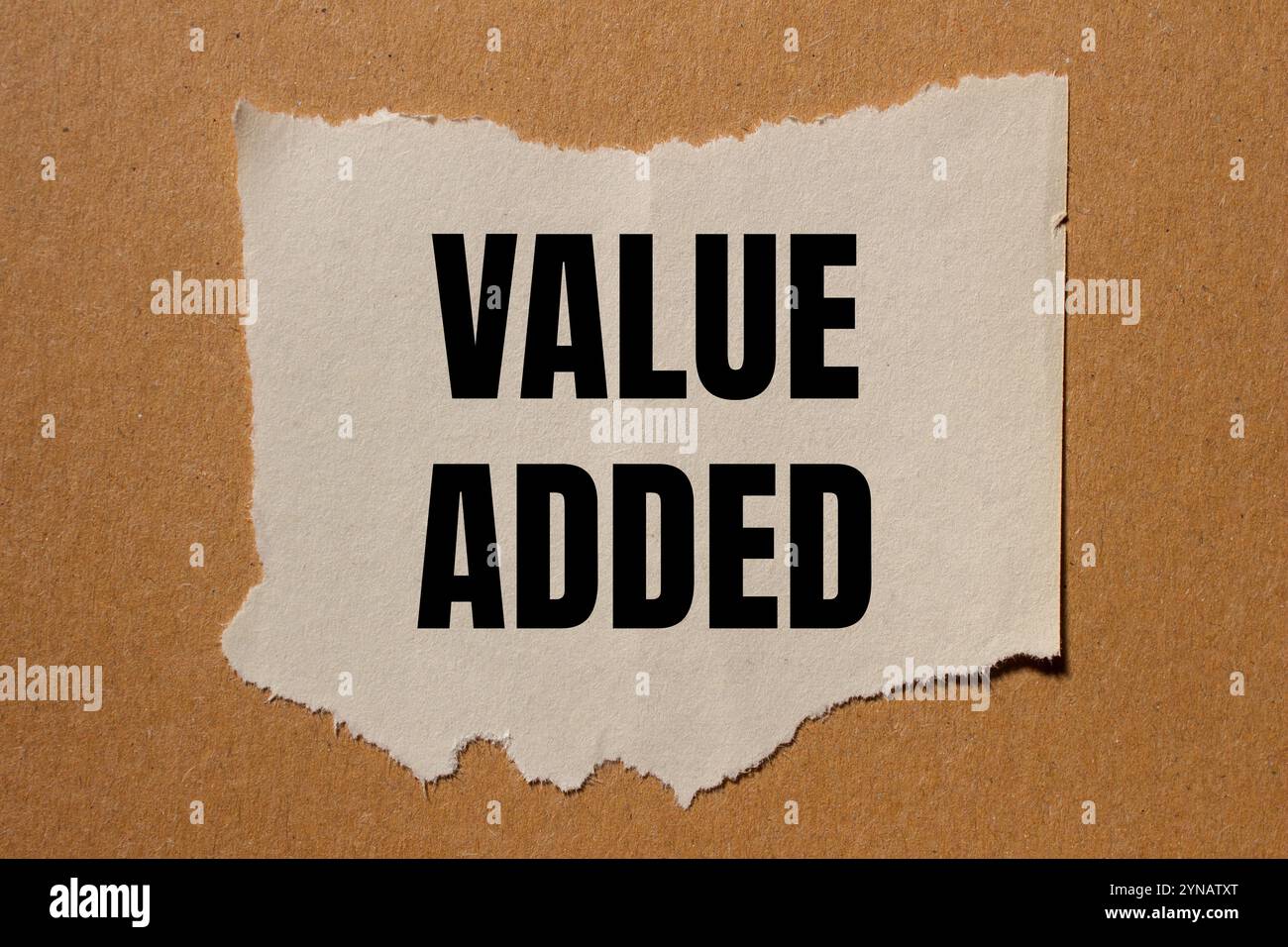 Value added message written on ripped torn paper piece with brown ...
