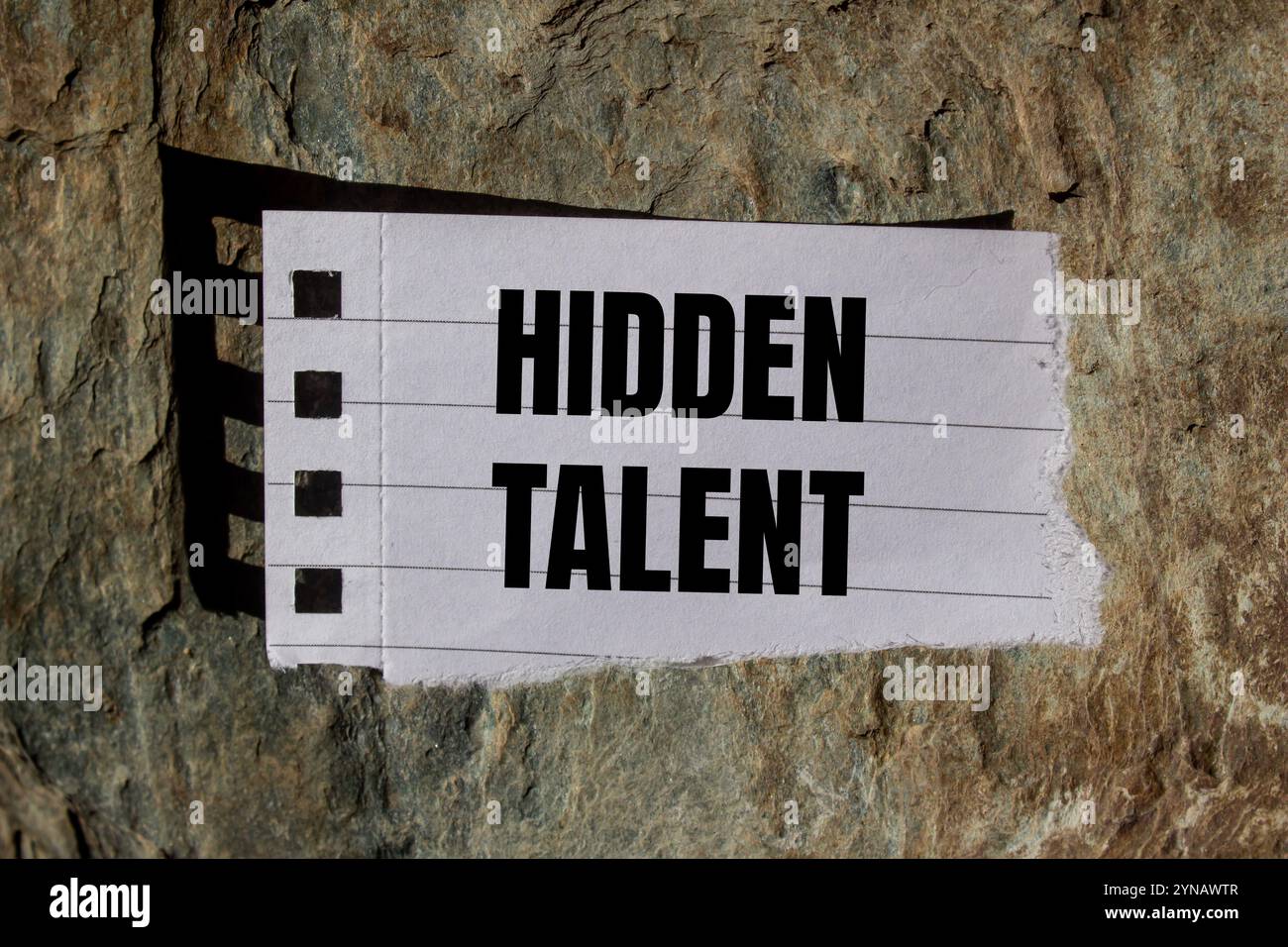 Hidden talent message written on ripped torn paper piece with stone ...