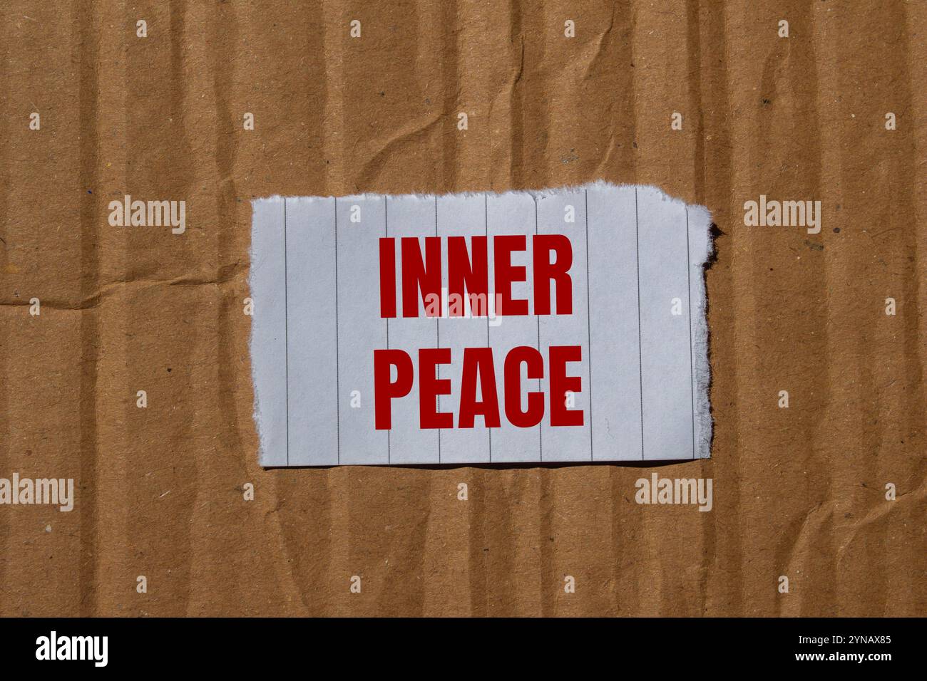Inner peace message written on ripped torn paper piece with cardboard ...