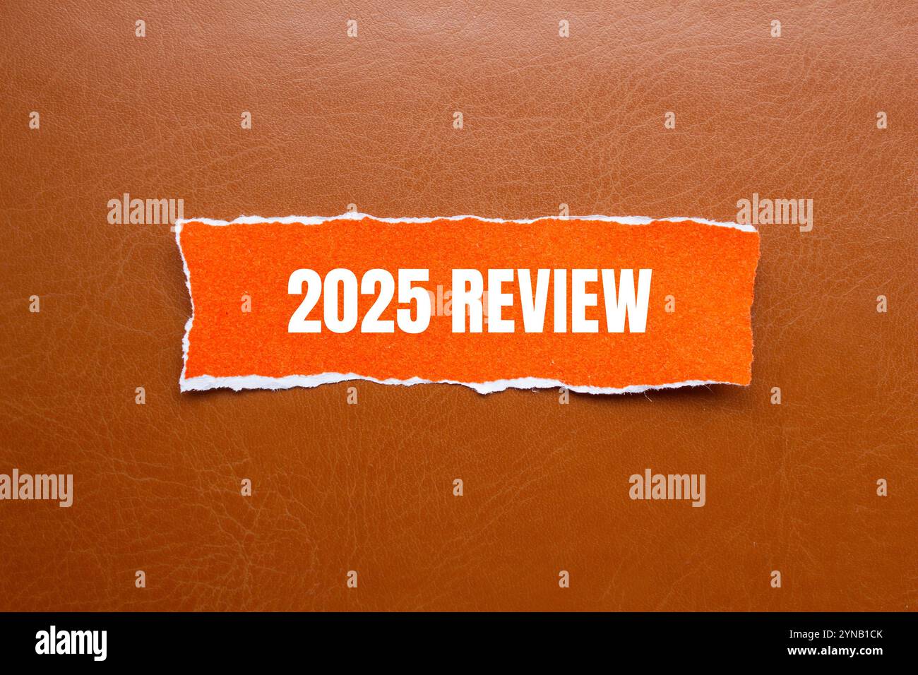 2025 review message written on ripped orange torn paper piece with ...