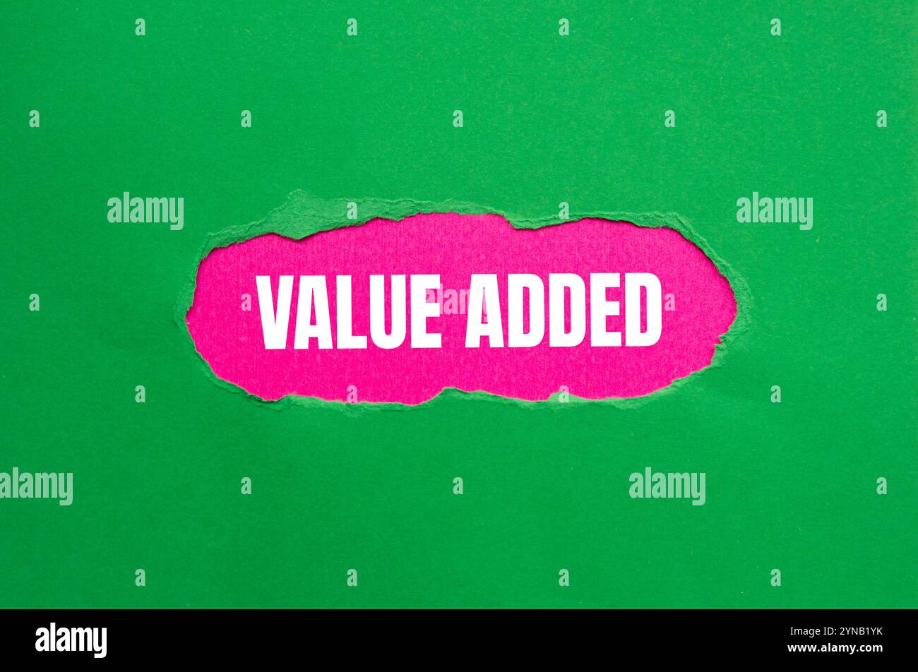 Value added message written on ripped torn green paper with pink ...