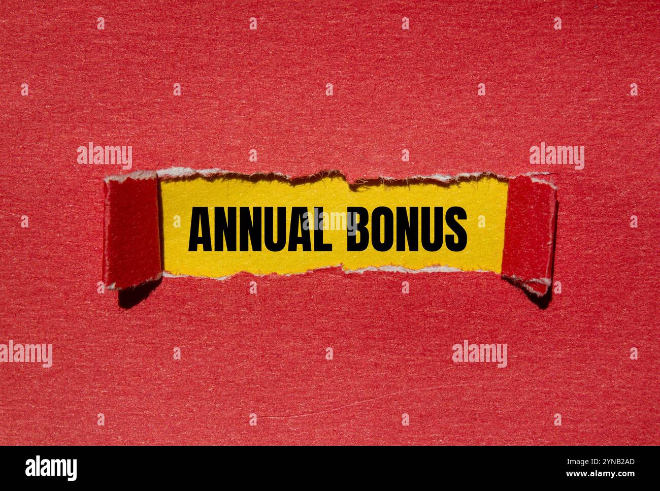 Annual bonus message written on ripped torn red paper with yellow ...