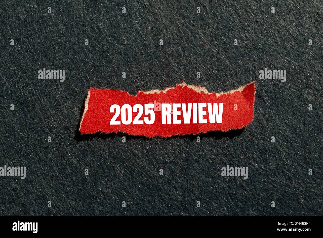 2025 review message written on ripped torn red paper piece with gray background. Conceptual 2025 ...