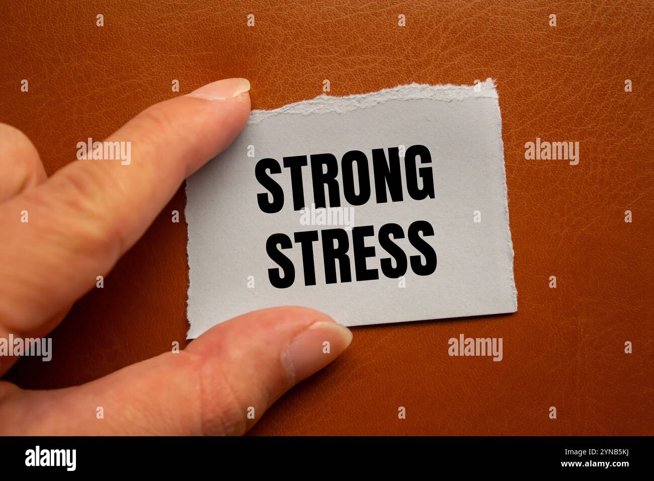 Strong stress message written on ripped torn paper piece with brown ...