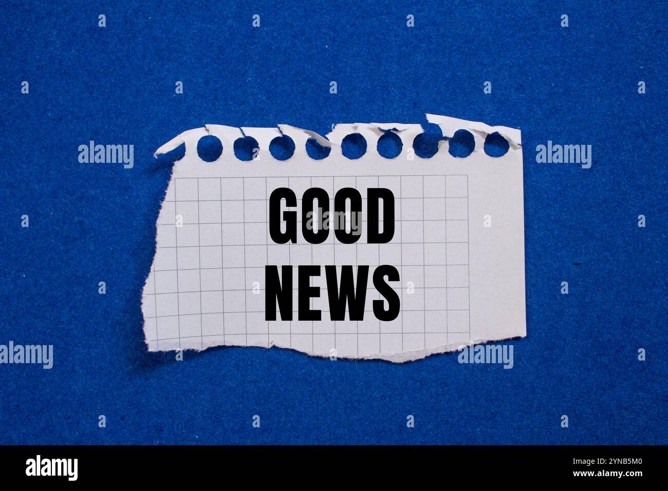 Good news message written on ripped torn paper piece with blue ...