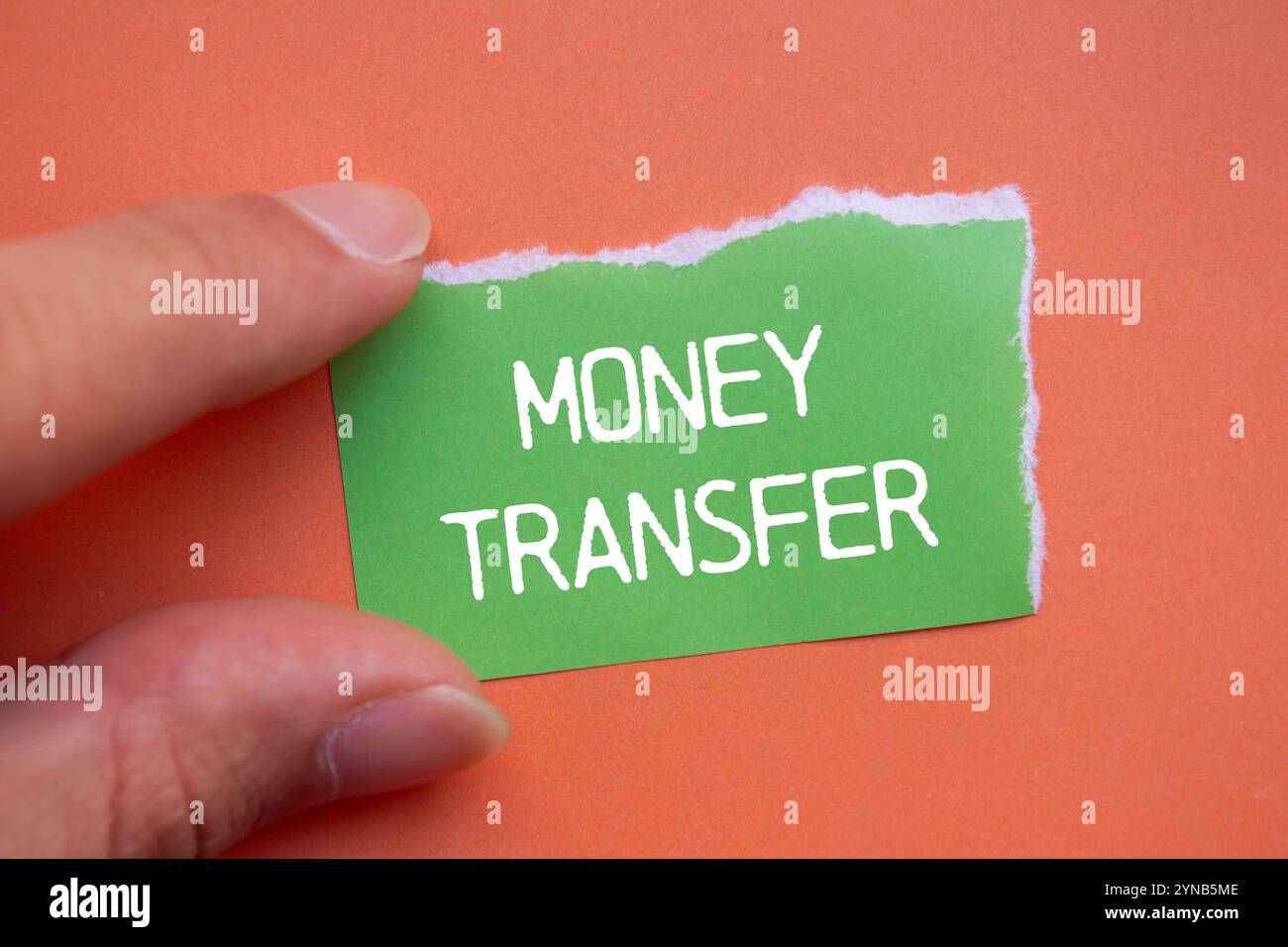 Money transfer message written on ripped green torn paper with orange ...