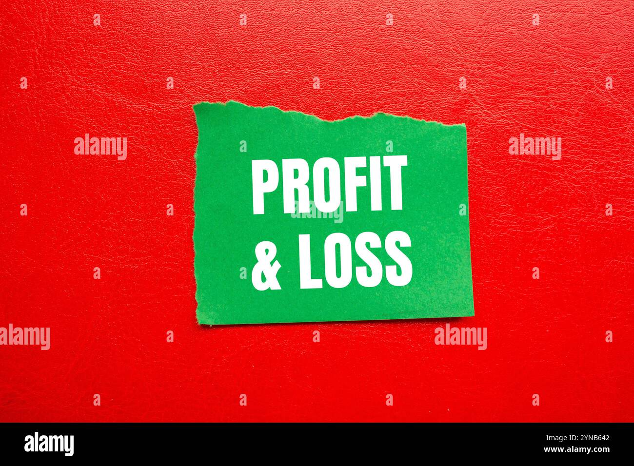 Profit and loss message written on ripped torn green paper piece with ...