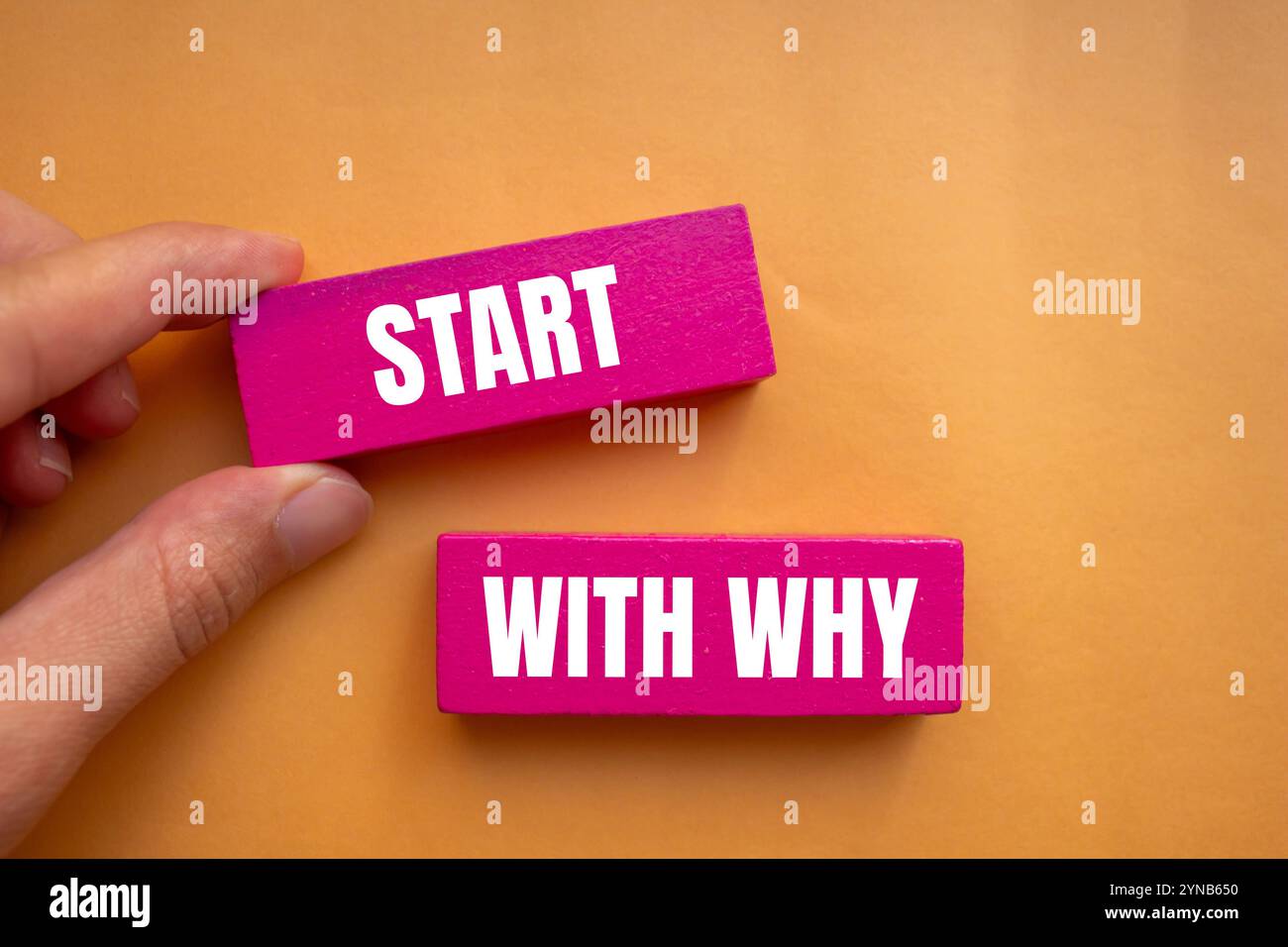 Start with why message written on pink wooden blocks with orange ...