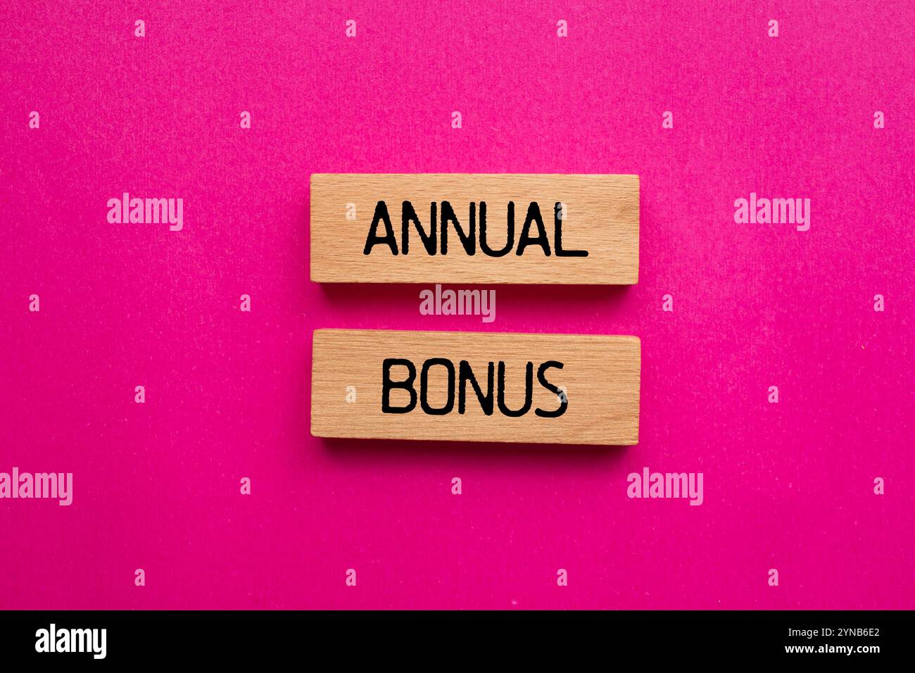 Annual bonus message written on wooden blocks with pink background ...