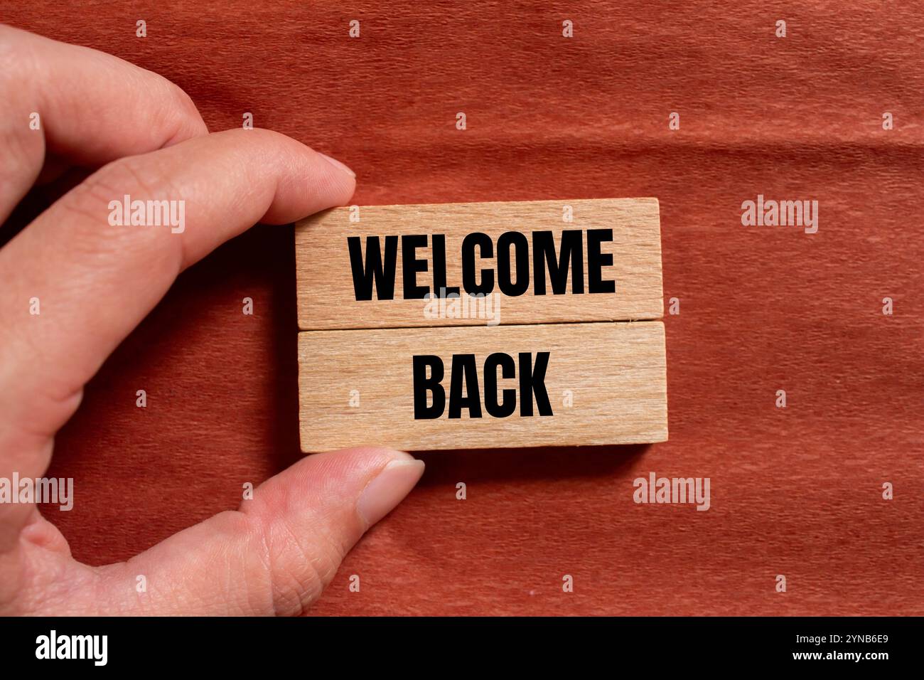 Welcome back message written on wooden blocks with brown background ...