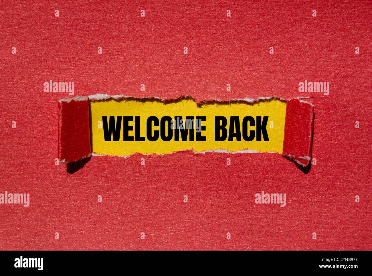 Welcome back message written on ripped torn red paper with yellow ...