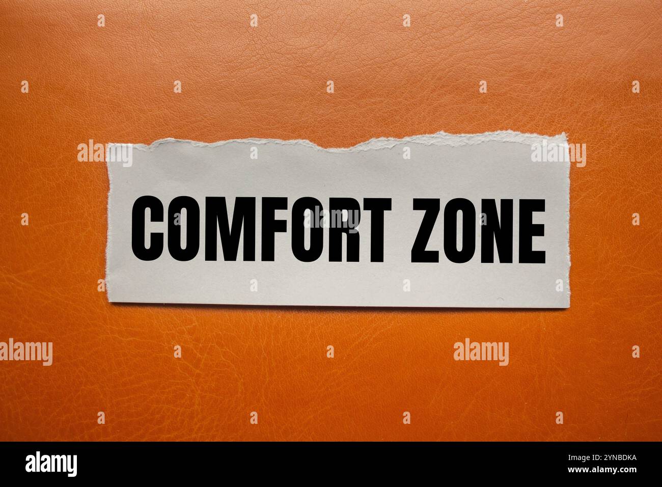 Comfort zone message written on ripped torn paper piece with brown ...
