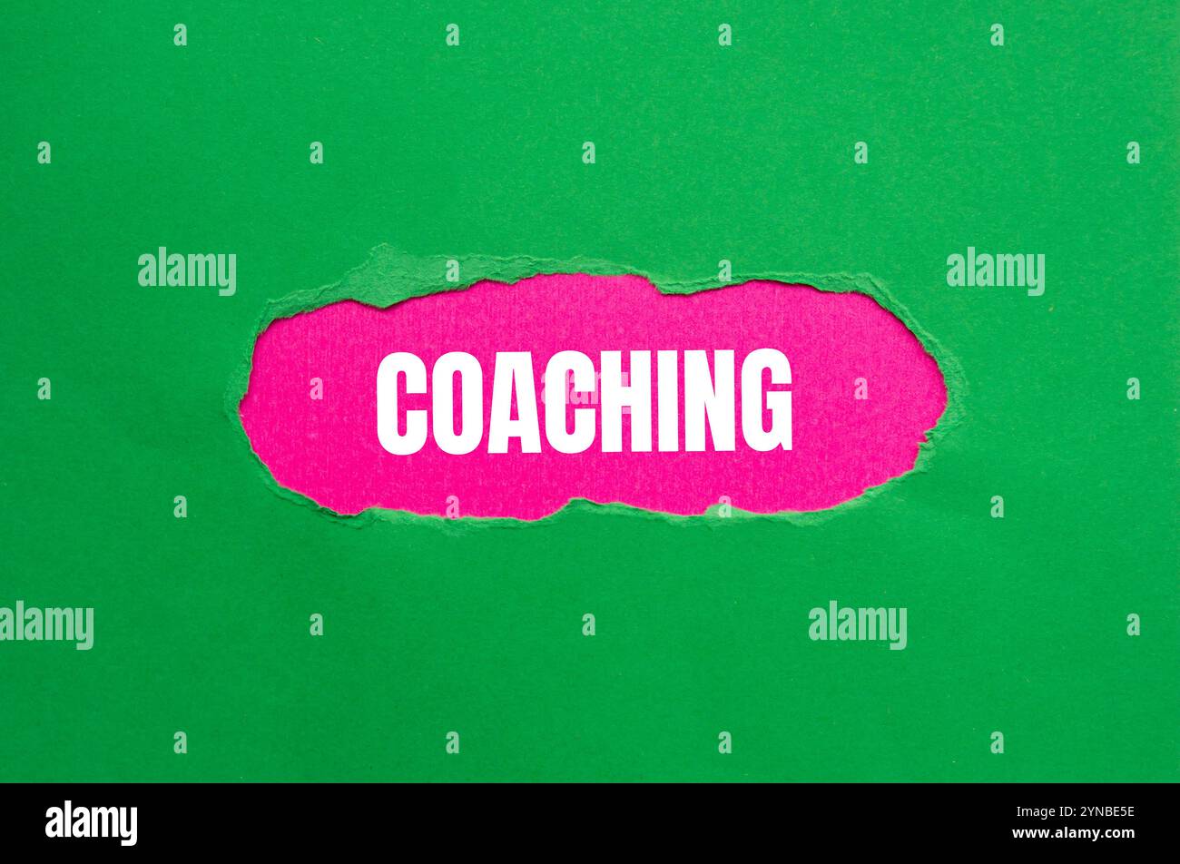 Coaching message written on ripped torn green paper with pink background. Conceptual coaching ...