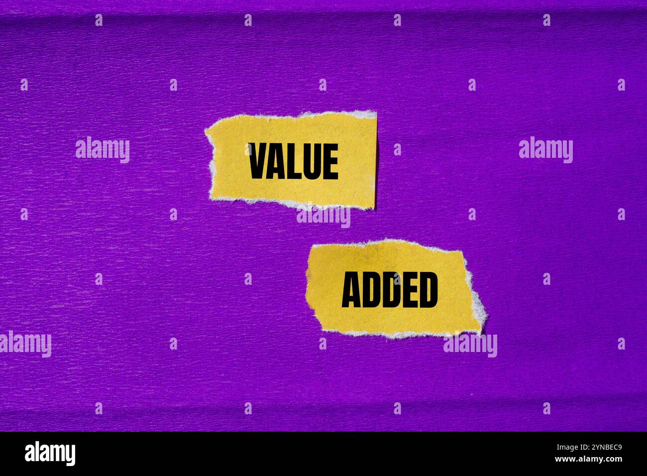 Value added message written on ripped torn yellow paper pieces with ...