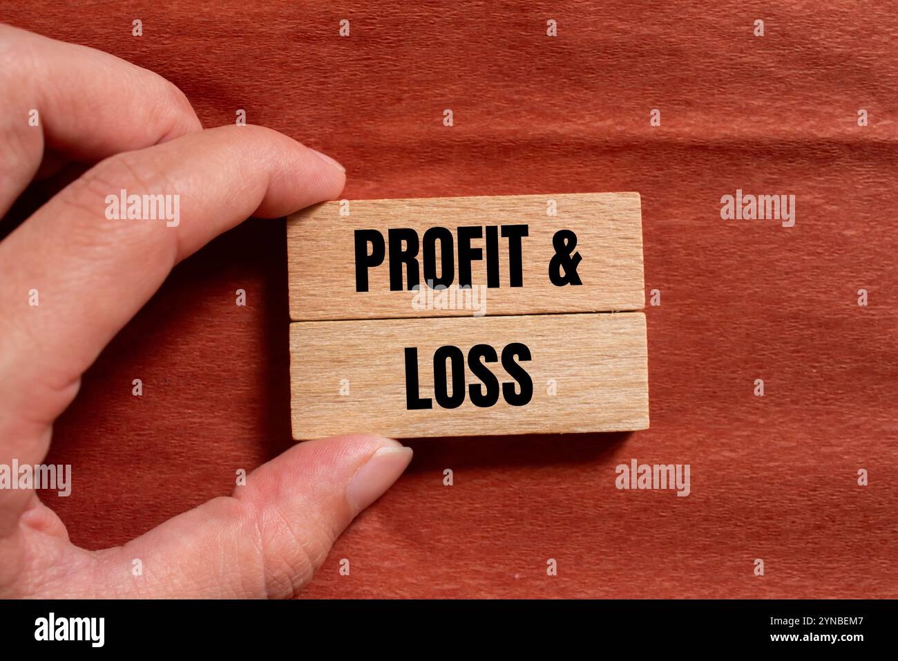 Profit and loss message written on wooden blocks with brown background ...