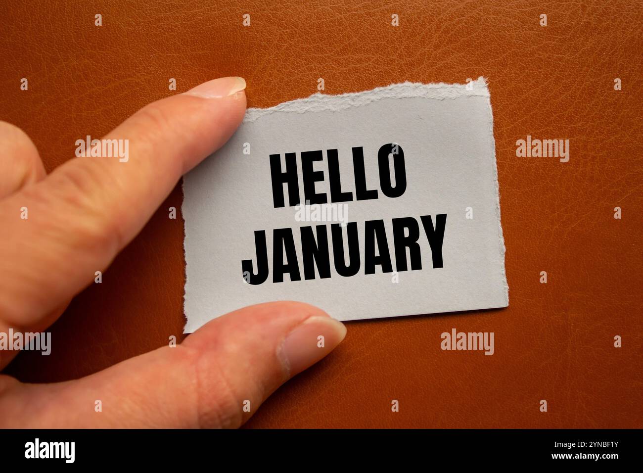 Hello january message written on ripped torn paper piece with brown ...