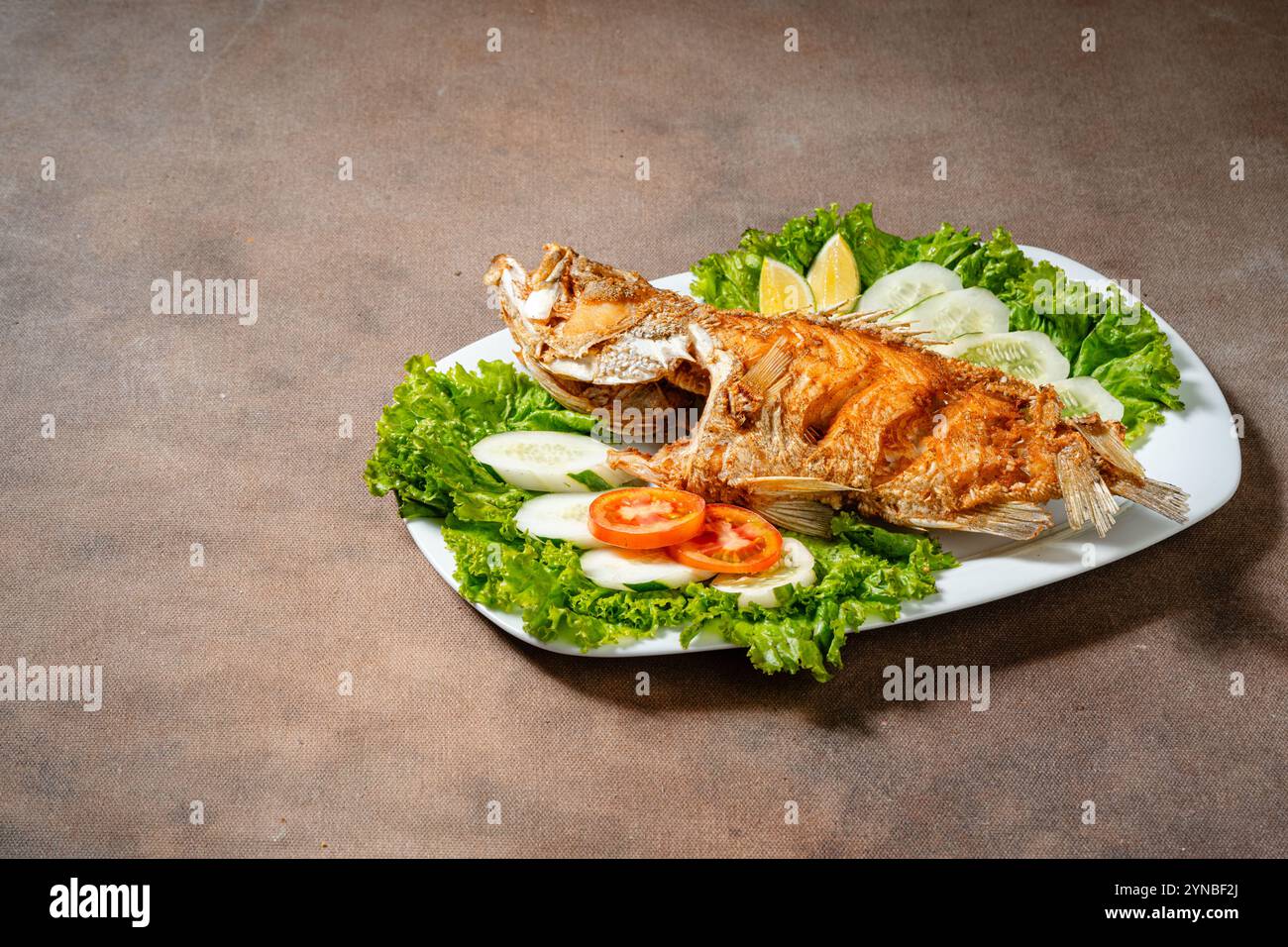 Deep fried crispy grouper fish with sambal dabu dabu Stock Photo - Alamy