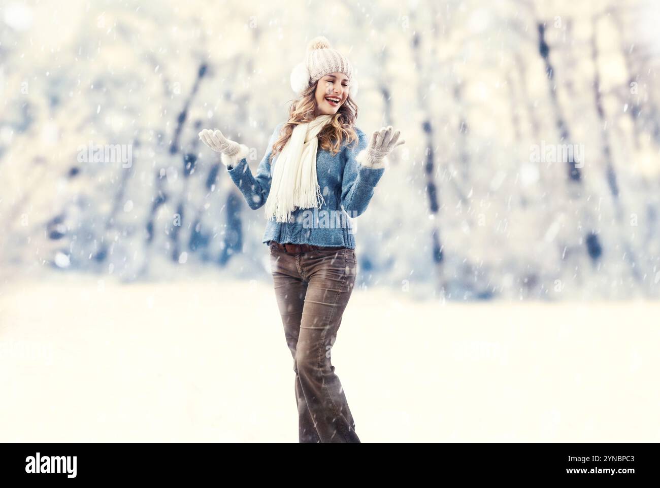 A cheerful and joyful woman embracing the beauty of a winter snowfall ...