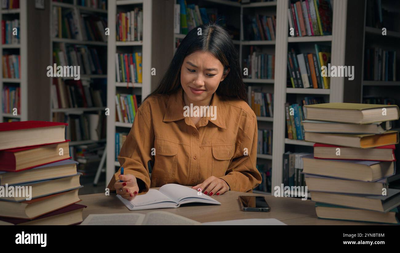 Asian woman female girl student in university library preparing exam studying using digital ...