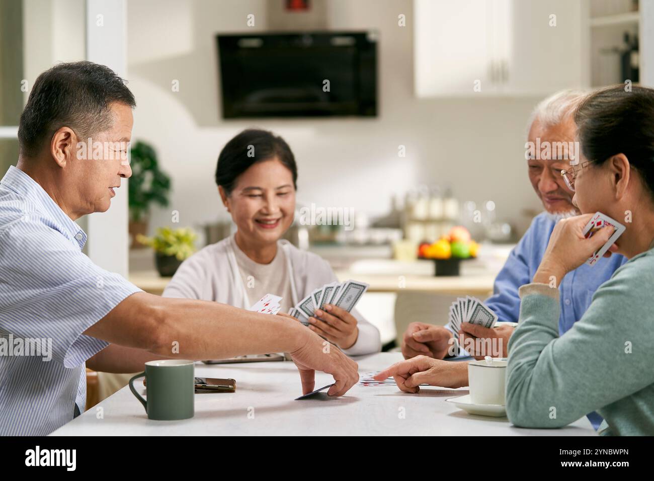 group of happy asian senior people two couples gathering at home playing cards together Stock ...