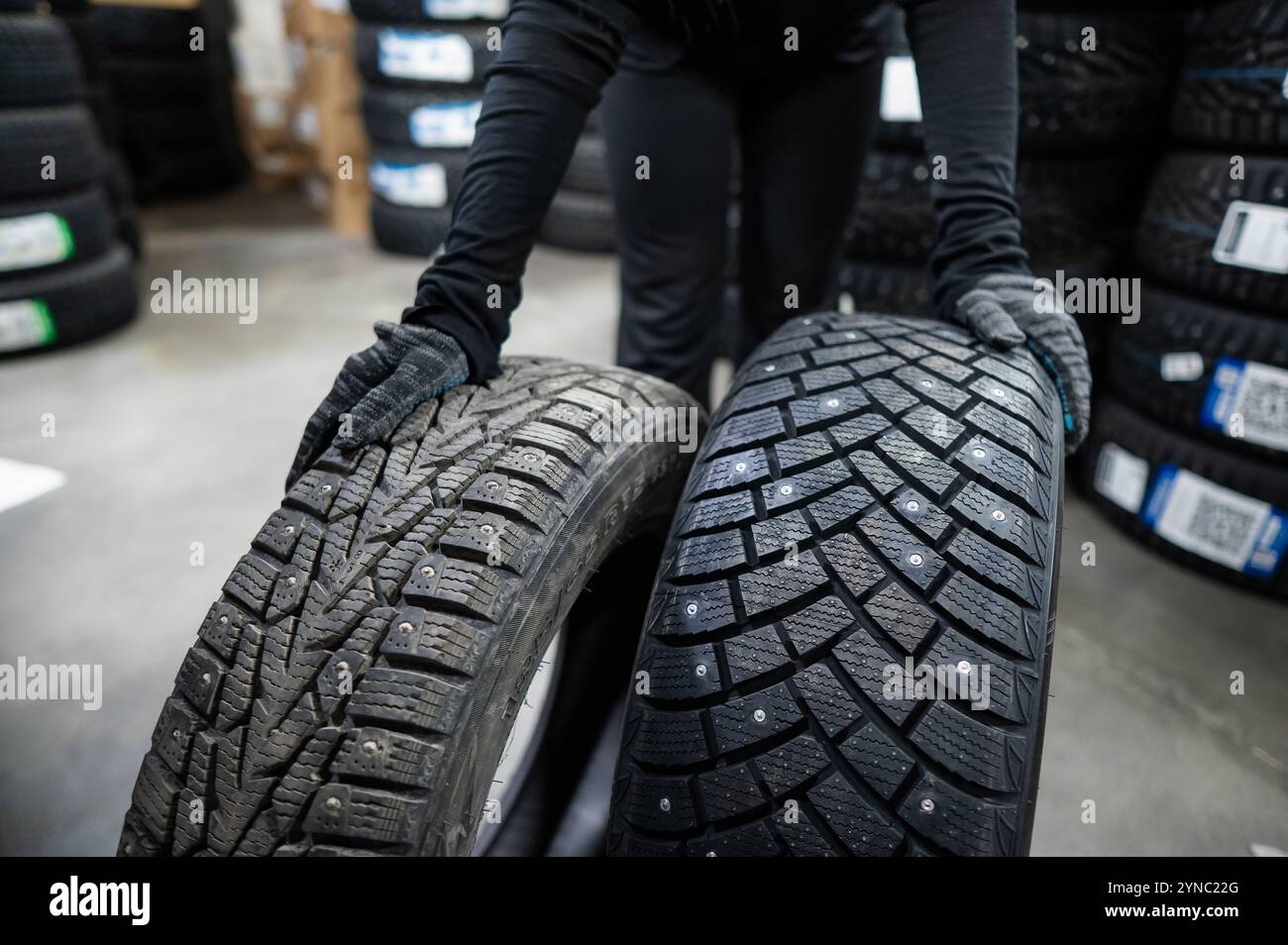 Mechanic keeps new summer and winter car tires in the garage. Comparison of wheels for different ...