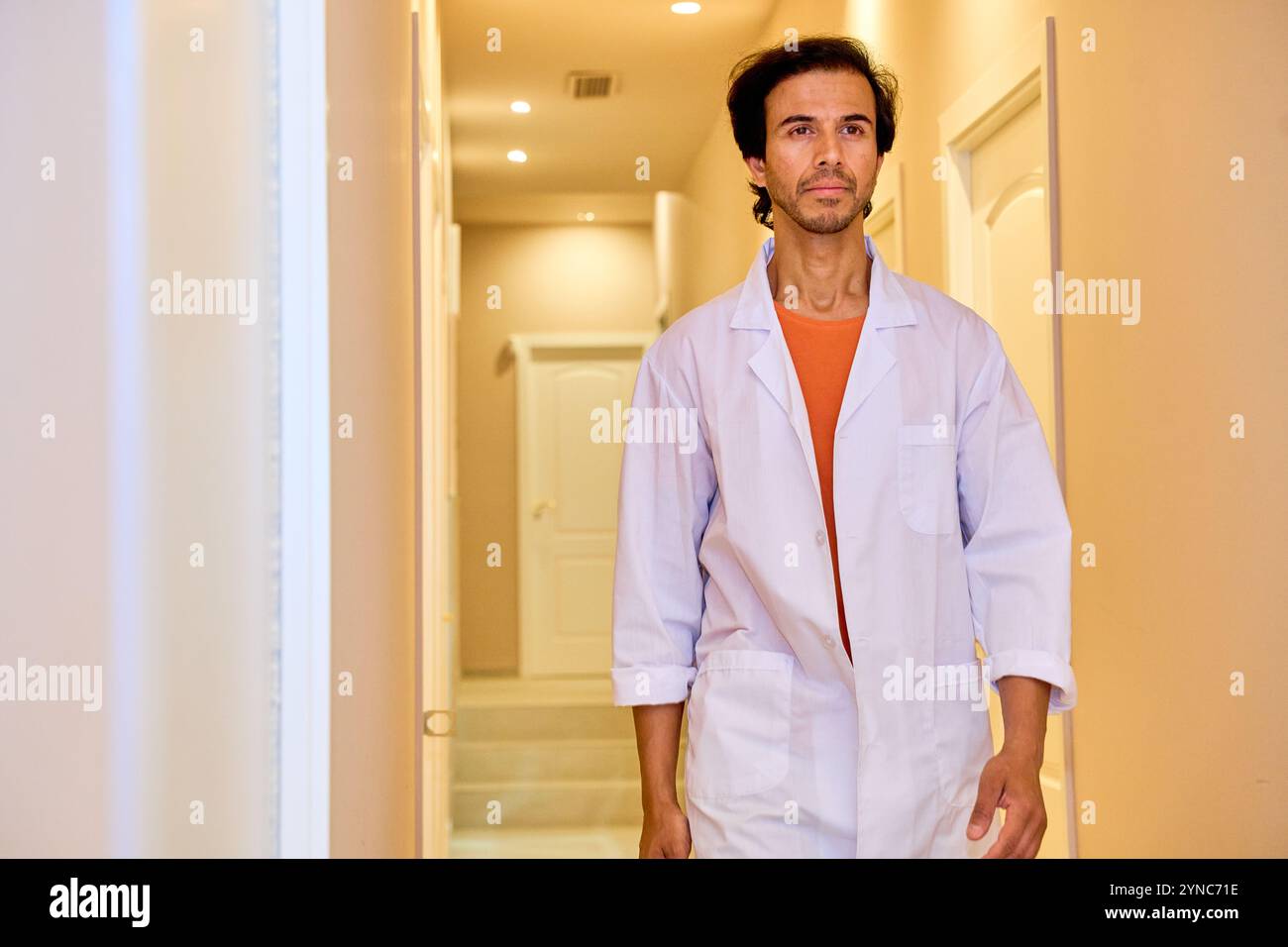 Male doctor walking through a hallway in a clinic Stock Photo - Alamy