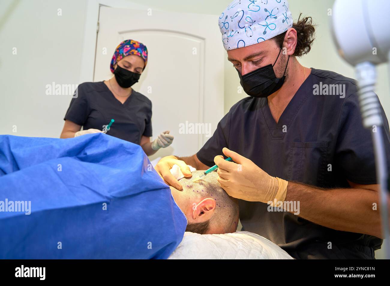 doctor putting anaesthesia on a patient's head in the operating room ...