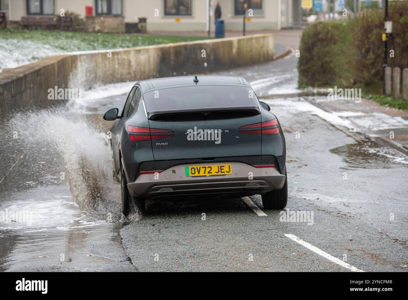 motor car driving through deep puddle during flooding after a storm and ...