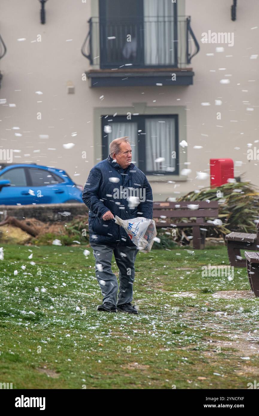 older man walking through a storm of spume and froth blown off of the ...