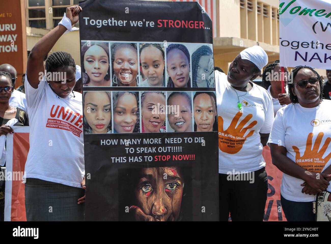 Activists chant slogans while holding a banner displaying the faces of ...