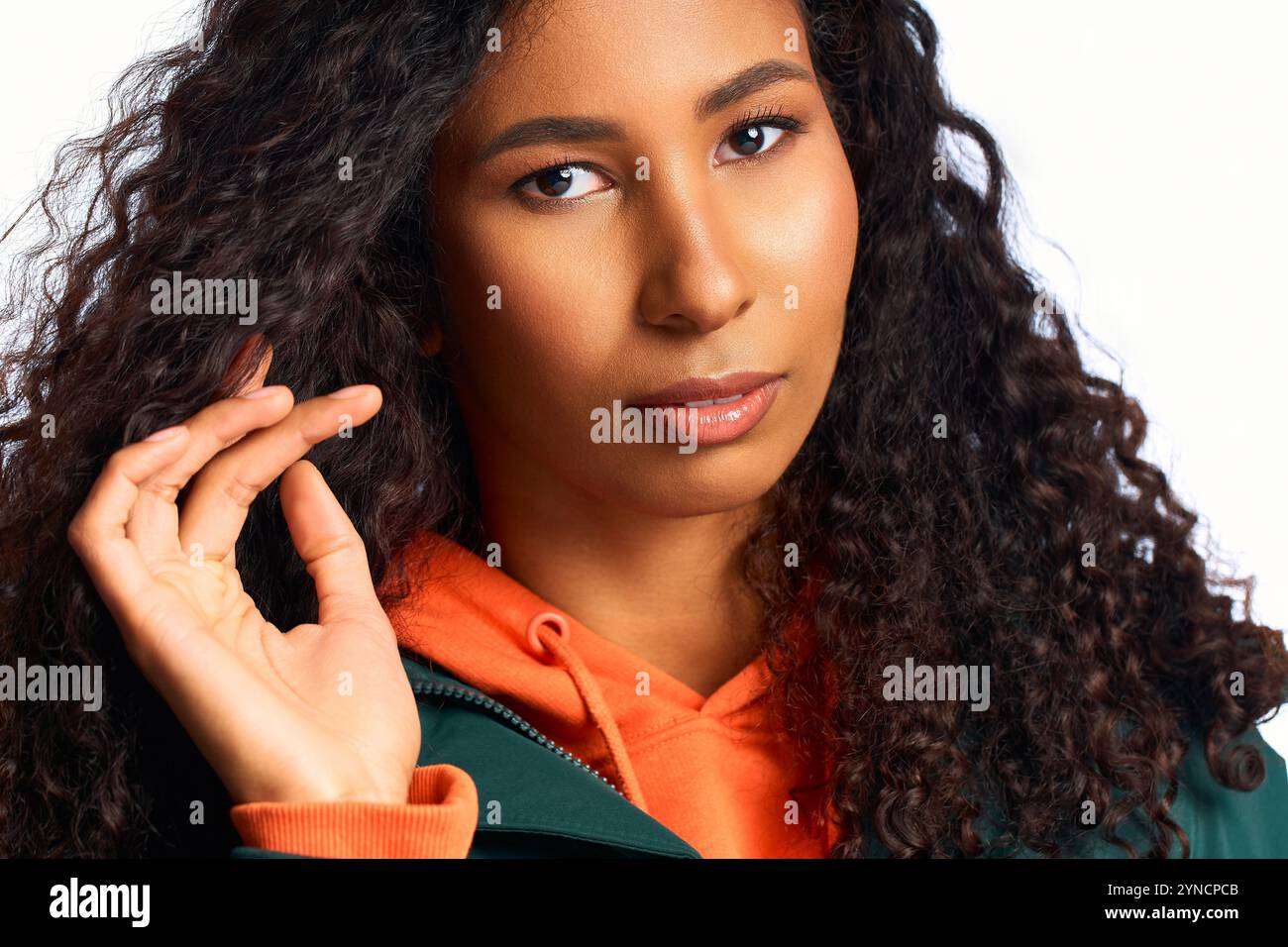 A confident woman showcases her striking features and beautiful curls ...