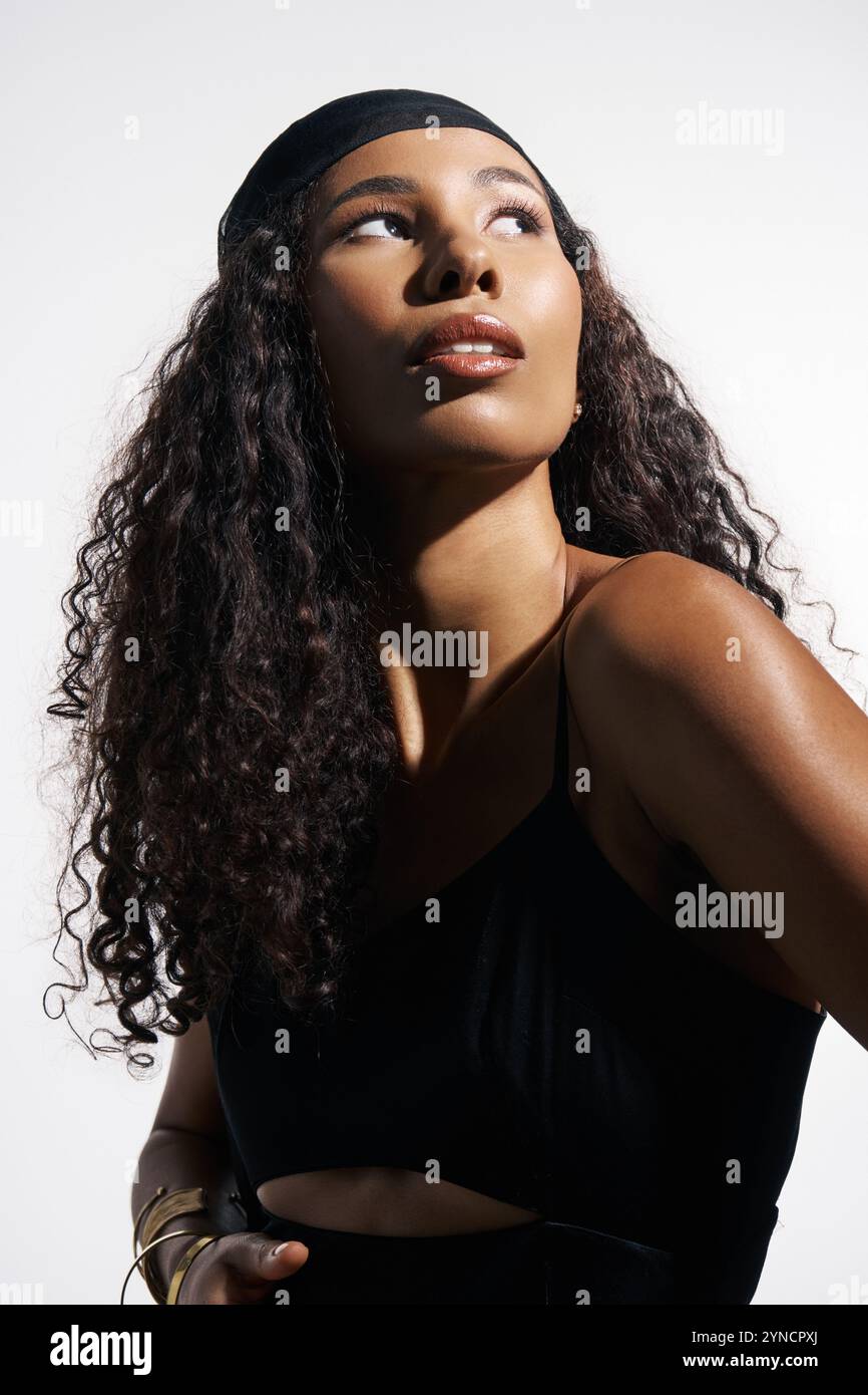 A beautiful woman with curly hair looks thoughtfully upwards in a ...
