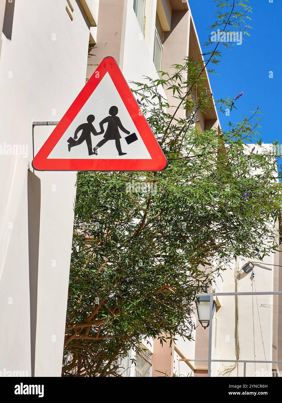 Traffic sign warning of children leaving school and crossing the street ...